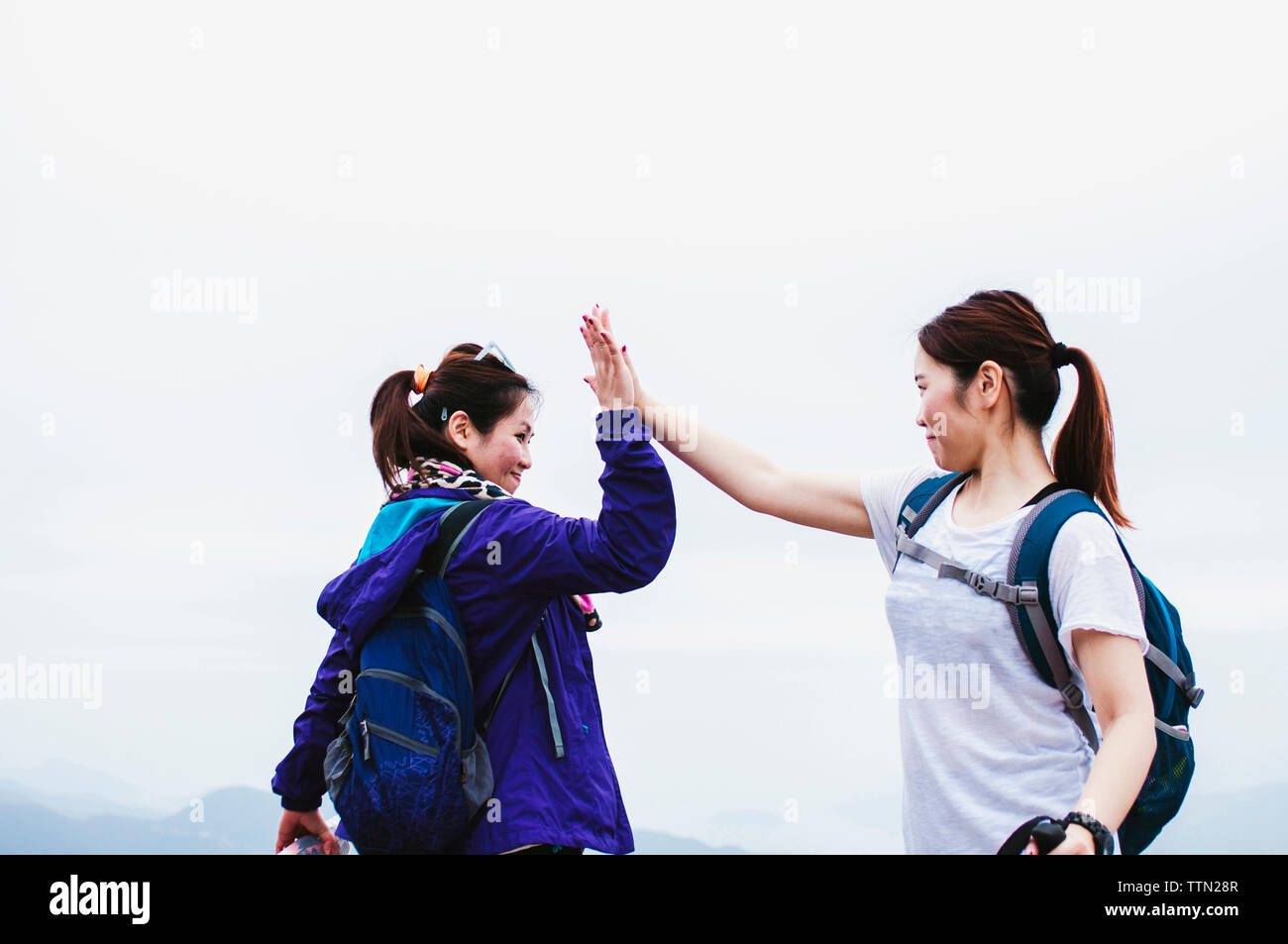 Two young women giving high five hi-res stock photography and images ...