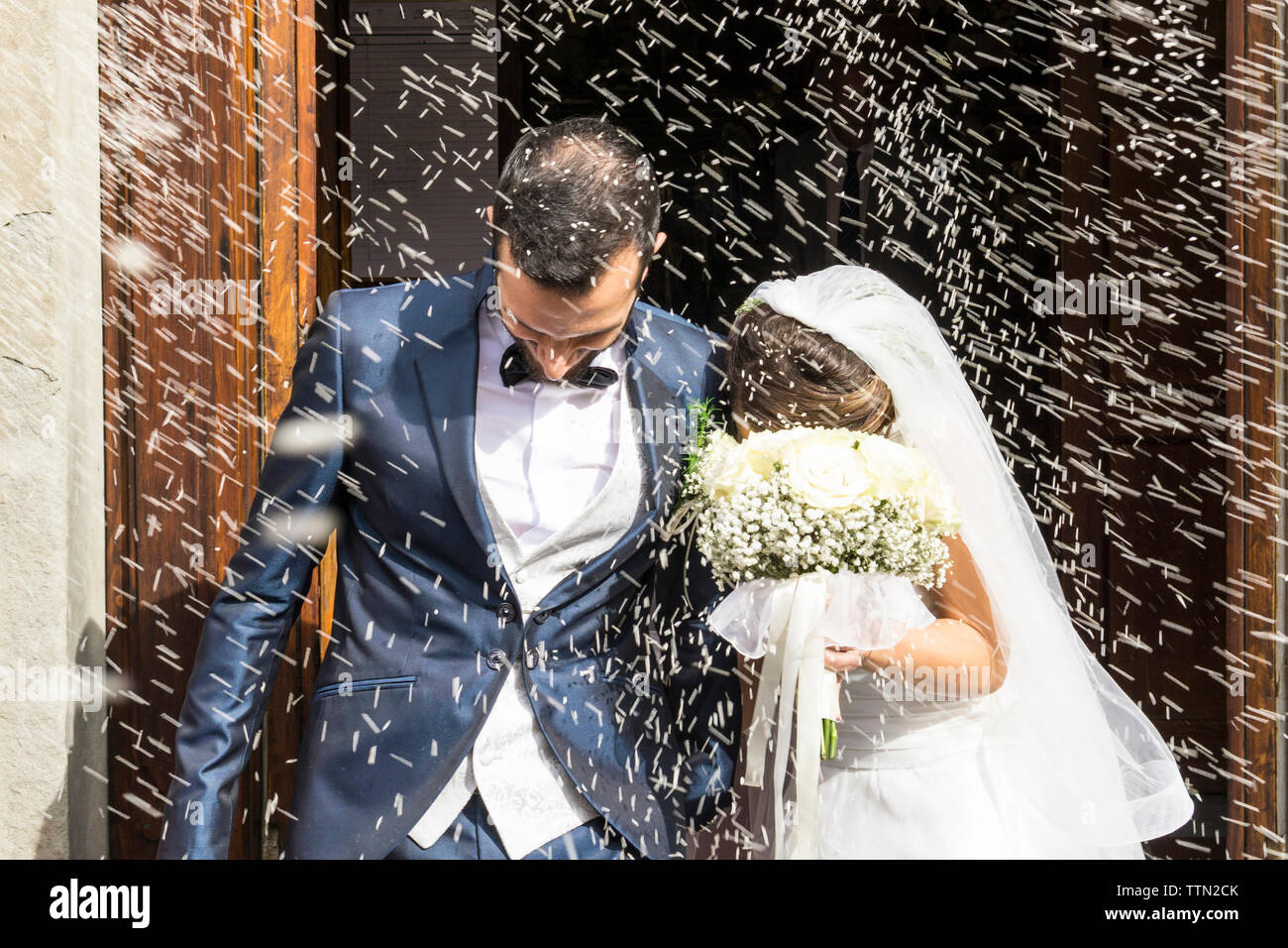 Confetti throwing on happy newlywed couple leaving from church Stock ...