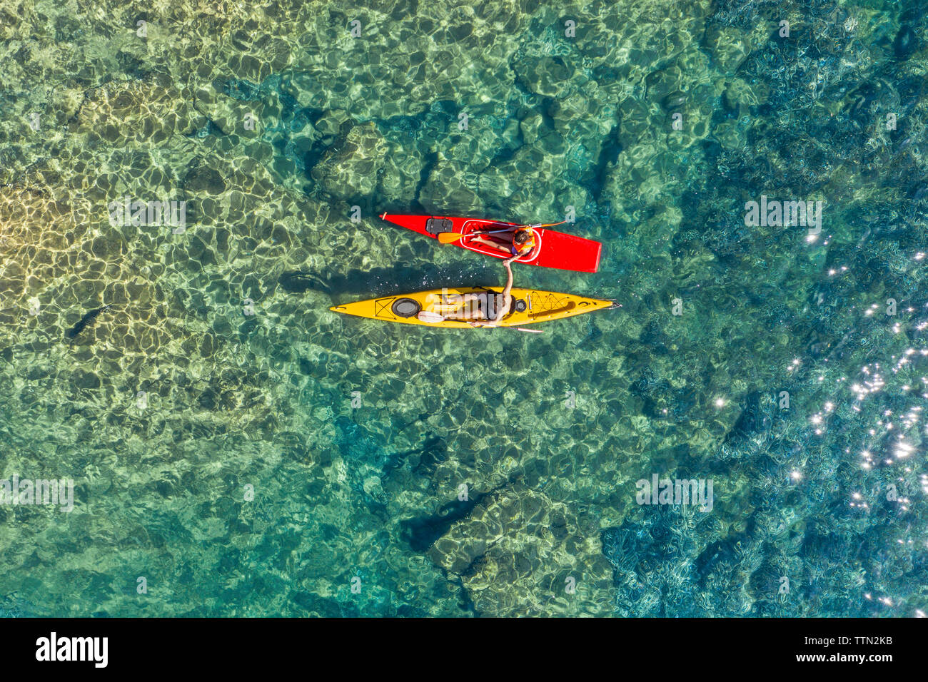 Drone shot of couple kayaking together in sea during sunny day Stock ...