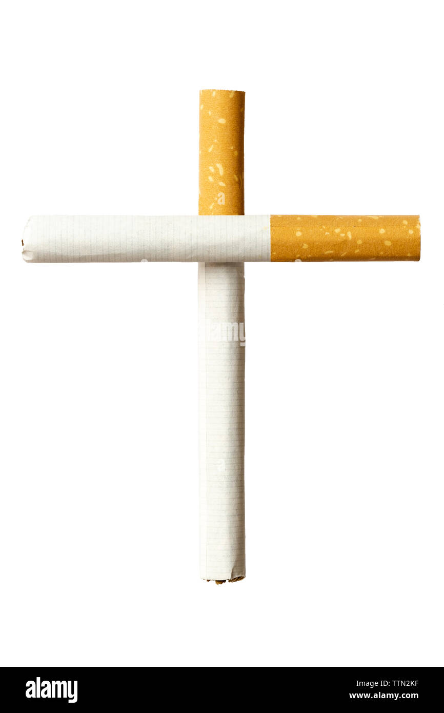 Close up of two cigarettes forming a tomb cross on white background ...