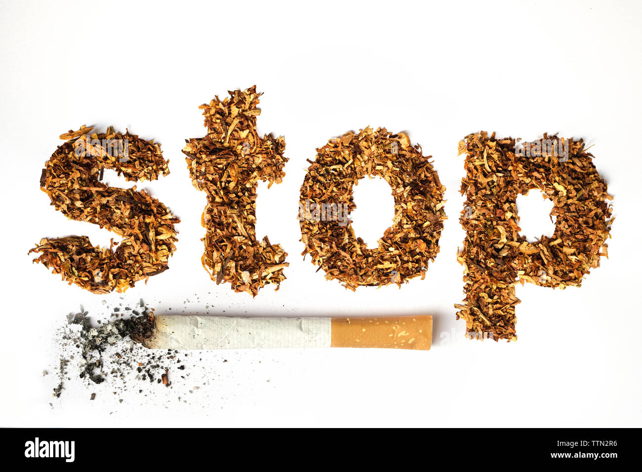 Frontal close up of the word STOP made of sliced cigarette tobacco on ...