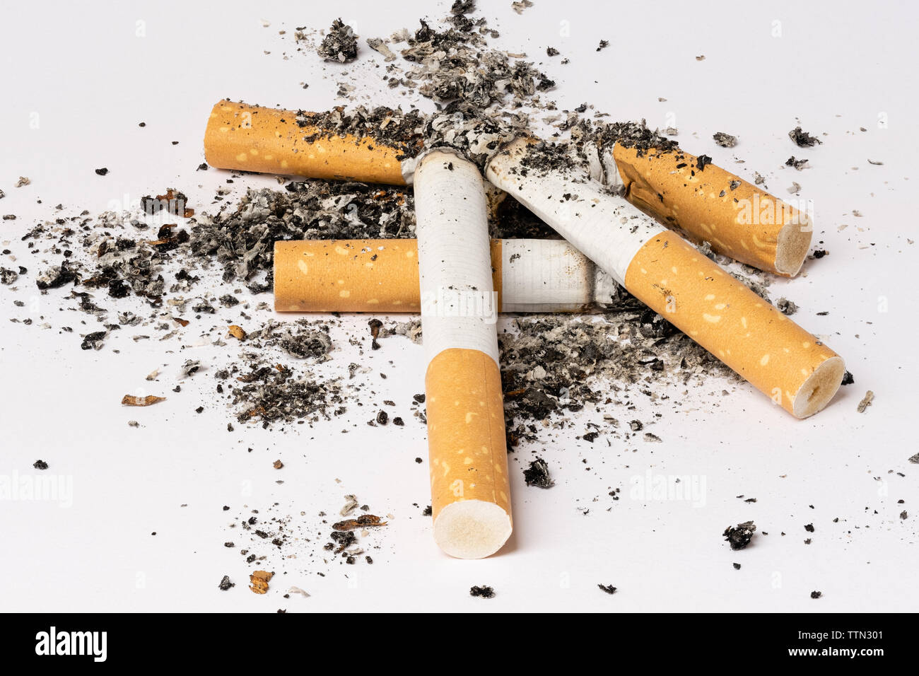 Burned cigarette butts with grey ashes, and two forming a cross in the ...