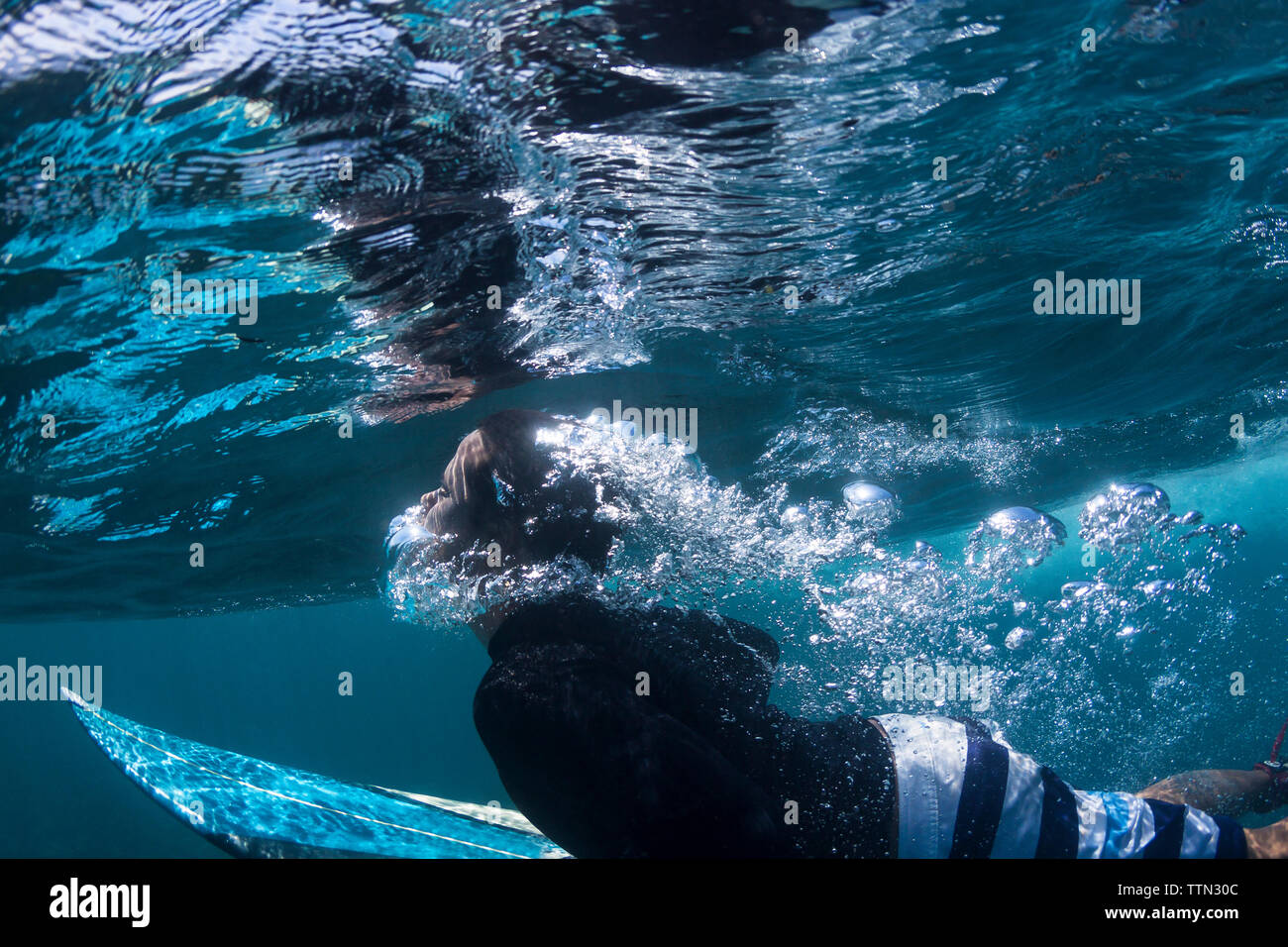 Side view of man surfing undersea Stock Photo - Alamy