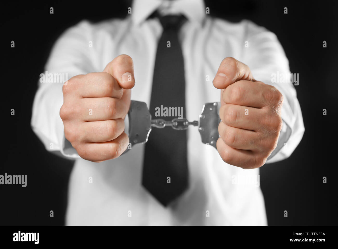 Man in handcuffs on grey background Stock Photo - Alamy