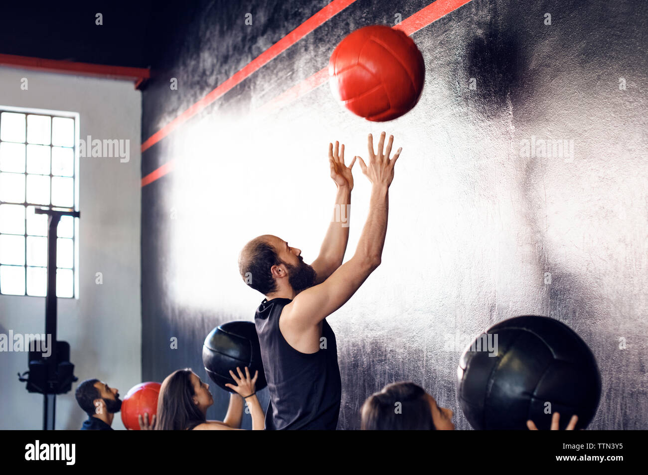 Athletes exercising with medicine balls in gym Stock Photo - Alamy