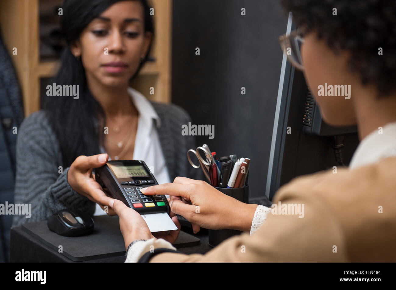 Woman doing payment at cash counter in store Stock Photo - Alamy