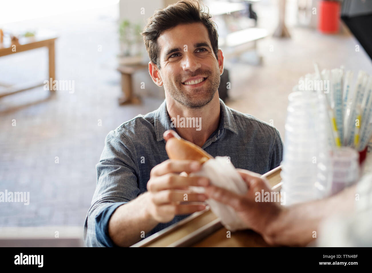 Customer receiving hotdog from male vendor at food truck Stock Photo ...