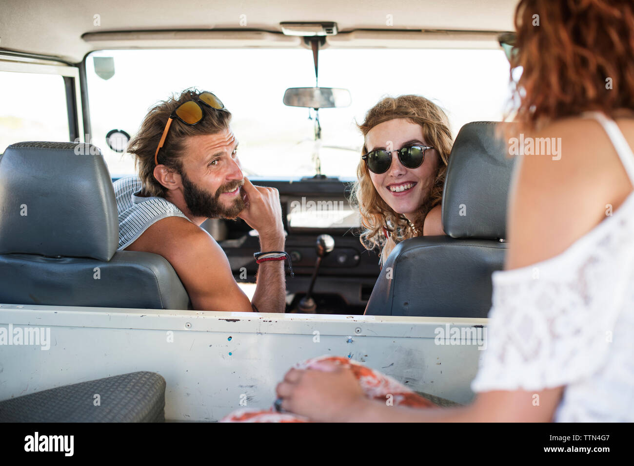 Happy friends talking in off-road vehicle Stock Photo - Alamy
