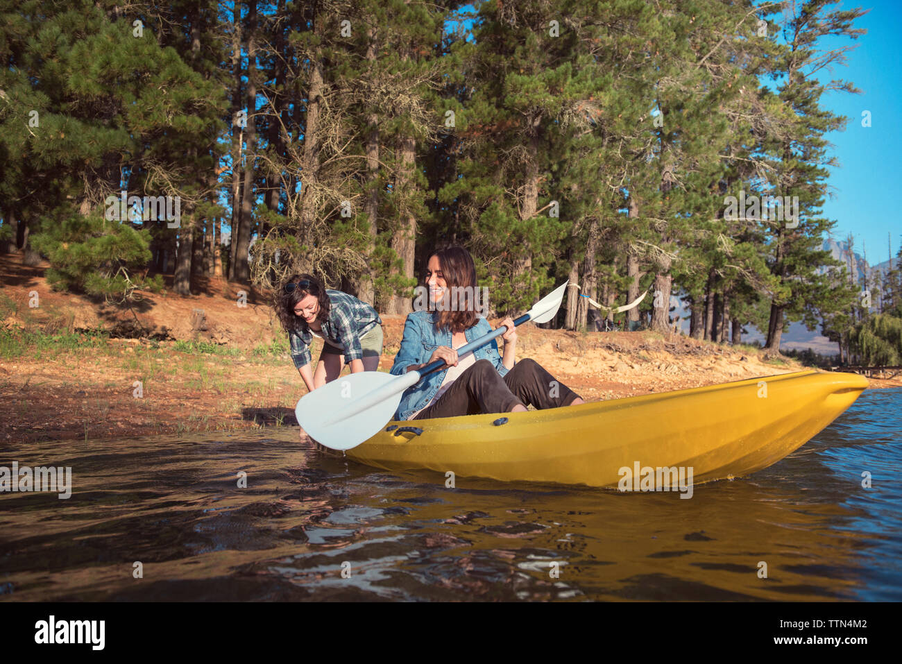 Happy female friends with kayak on lake Stock Photo - Alamy