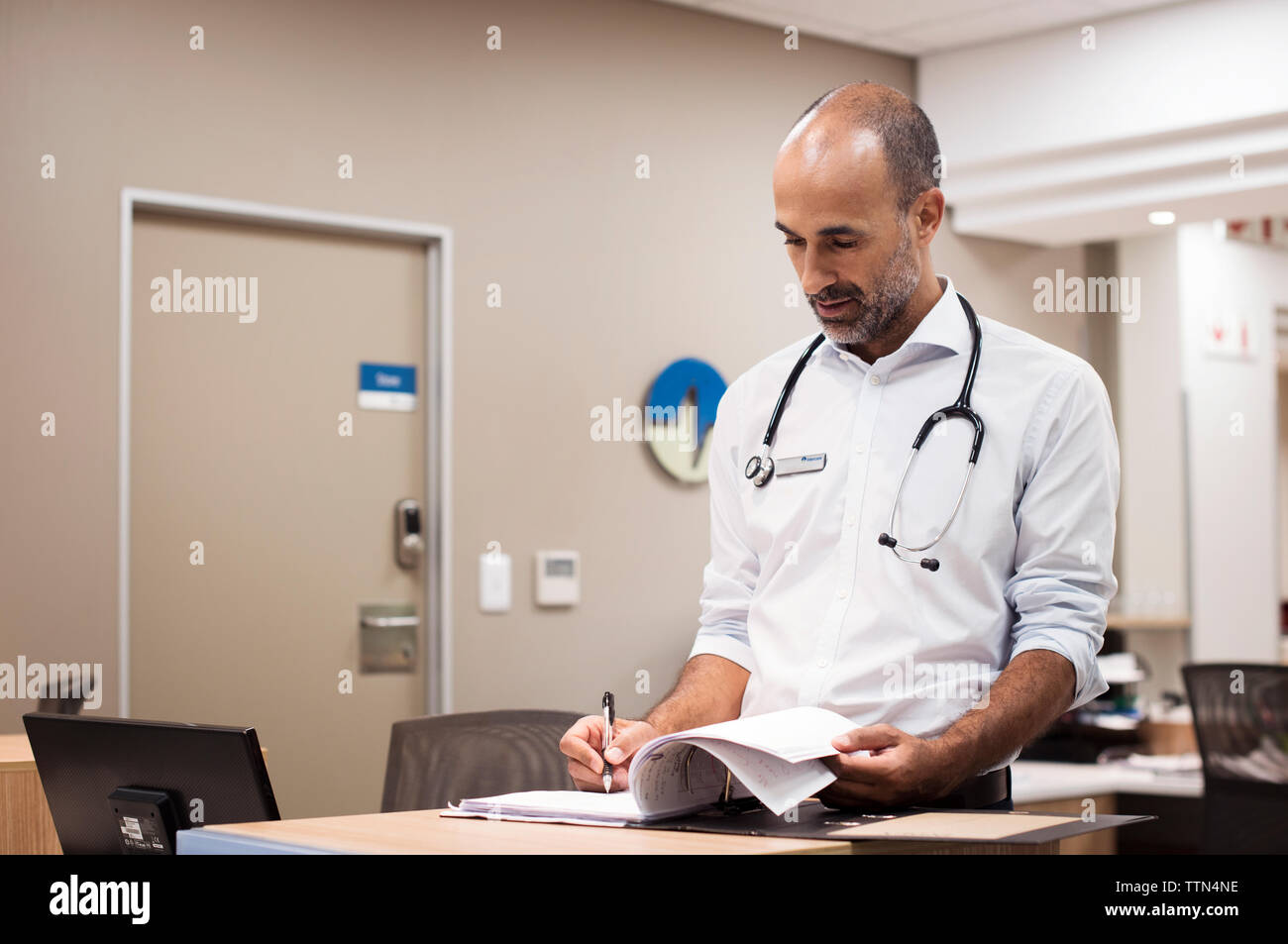 Doctor preparing reports while working in hospital Stock Photo - Alamy