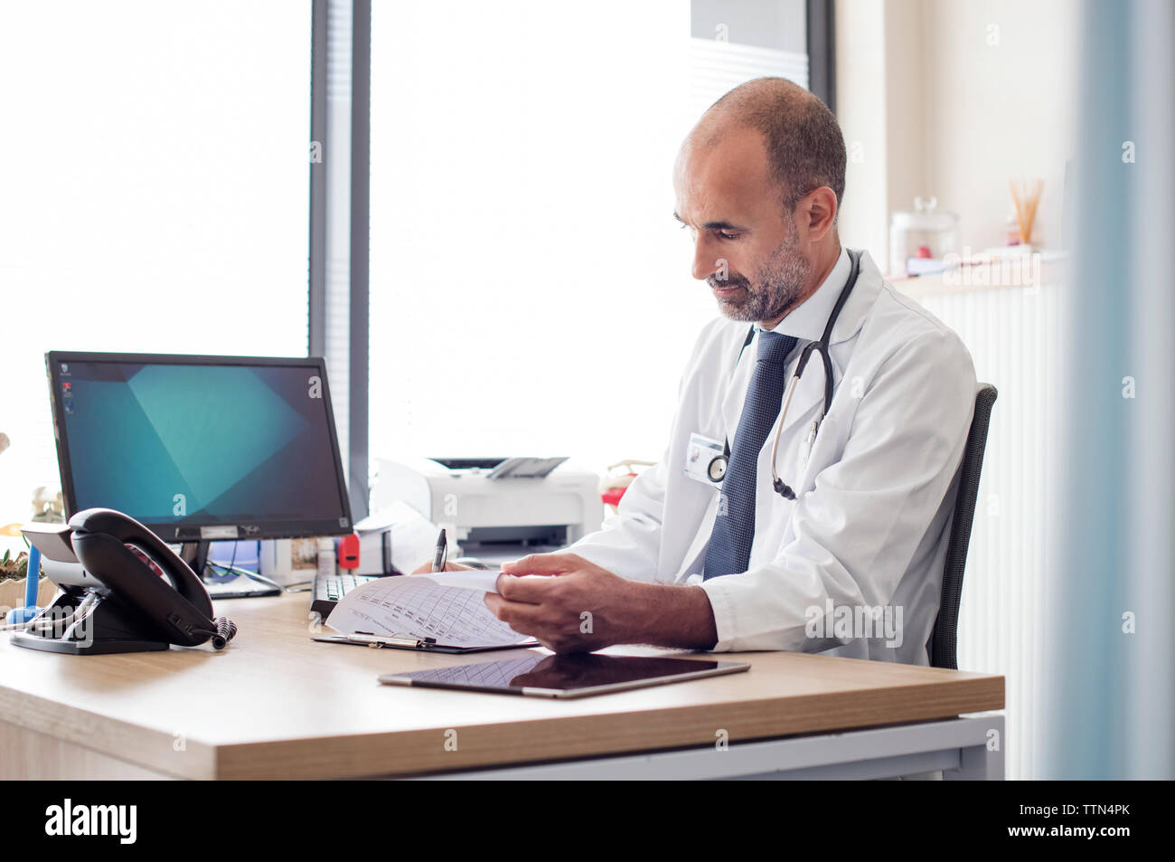 Doctor at table hi-res stock photography and images - Alamy