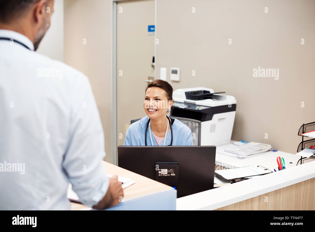 Doctors talking at hospital reception Stock Photo - Alamy