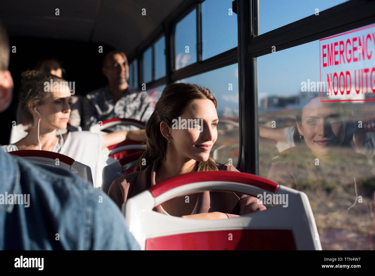 Passengers looking through window while traveling in tour bus Stock ...