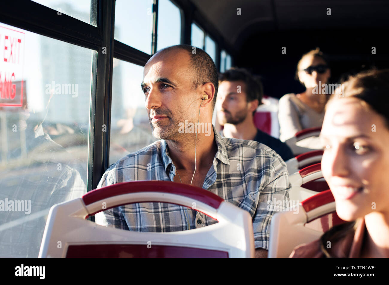 Passengers looking through window while traveling in bus Stock Photo ...