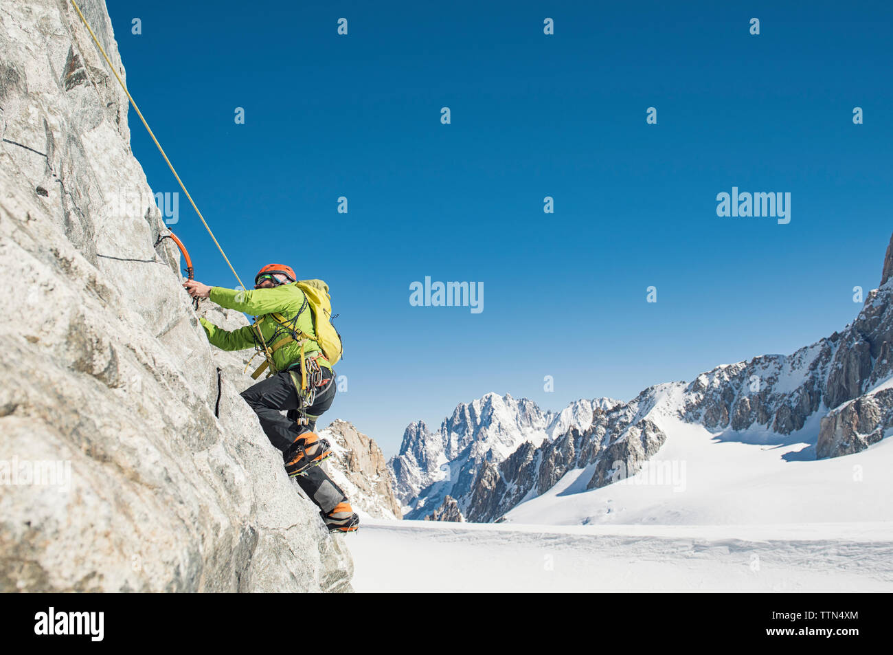 Side view of hiker climbing mountain against clear blue sky during ...