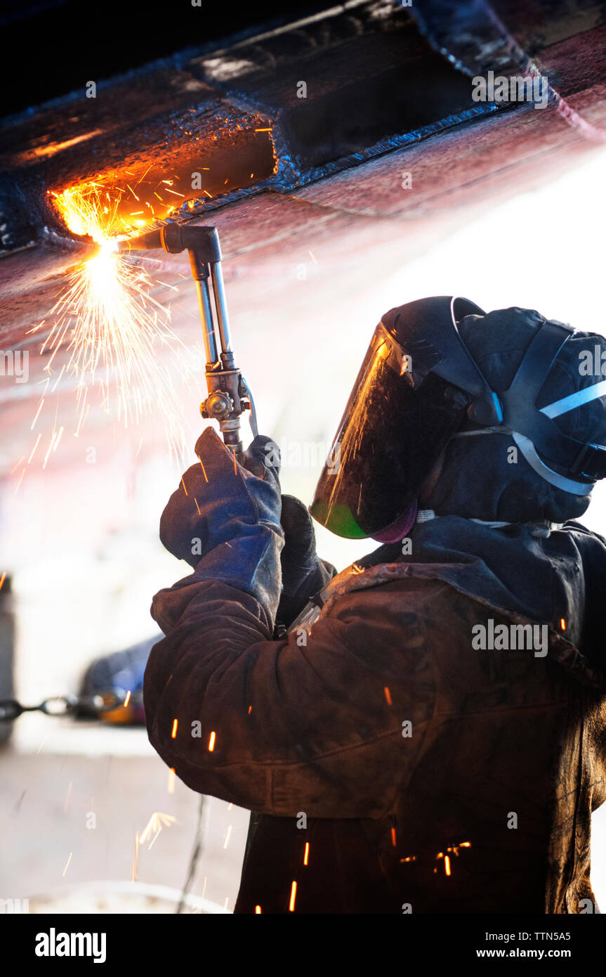 Side view of worker welding ship at industry Stock Photo - Alamy