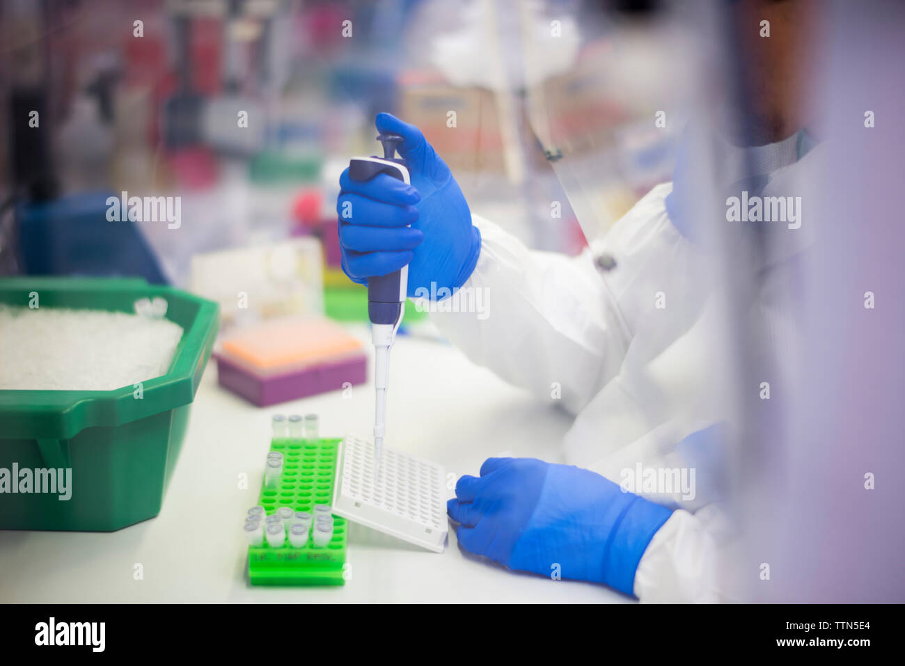 High angle view of scientist using pipette in laboratory seen through ...
