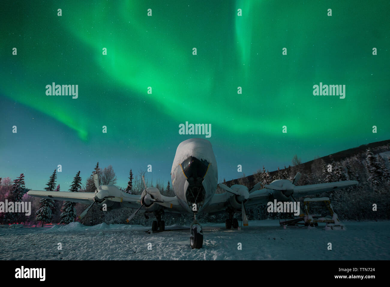 Snow covered airplane against aurora borealis Stock Photo - Alamy