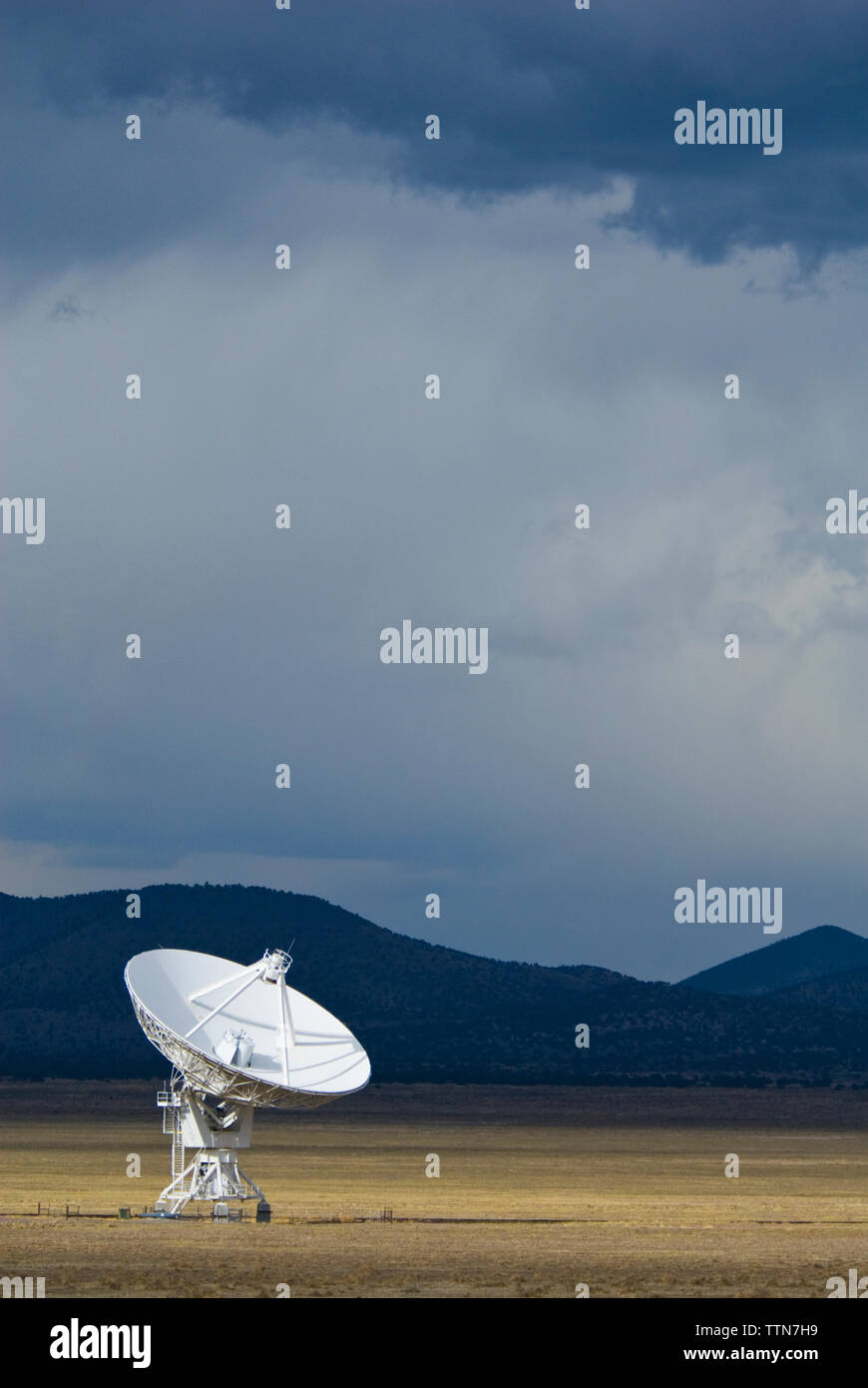 Satellite dish on field against cloudy sky at dusk Stock Photo - Alamy