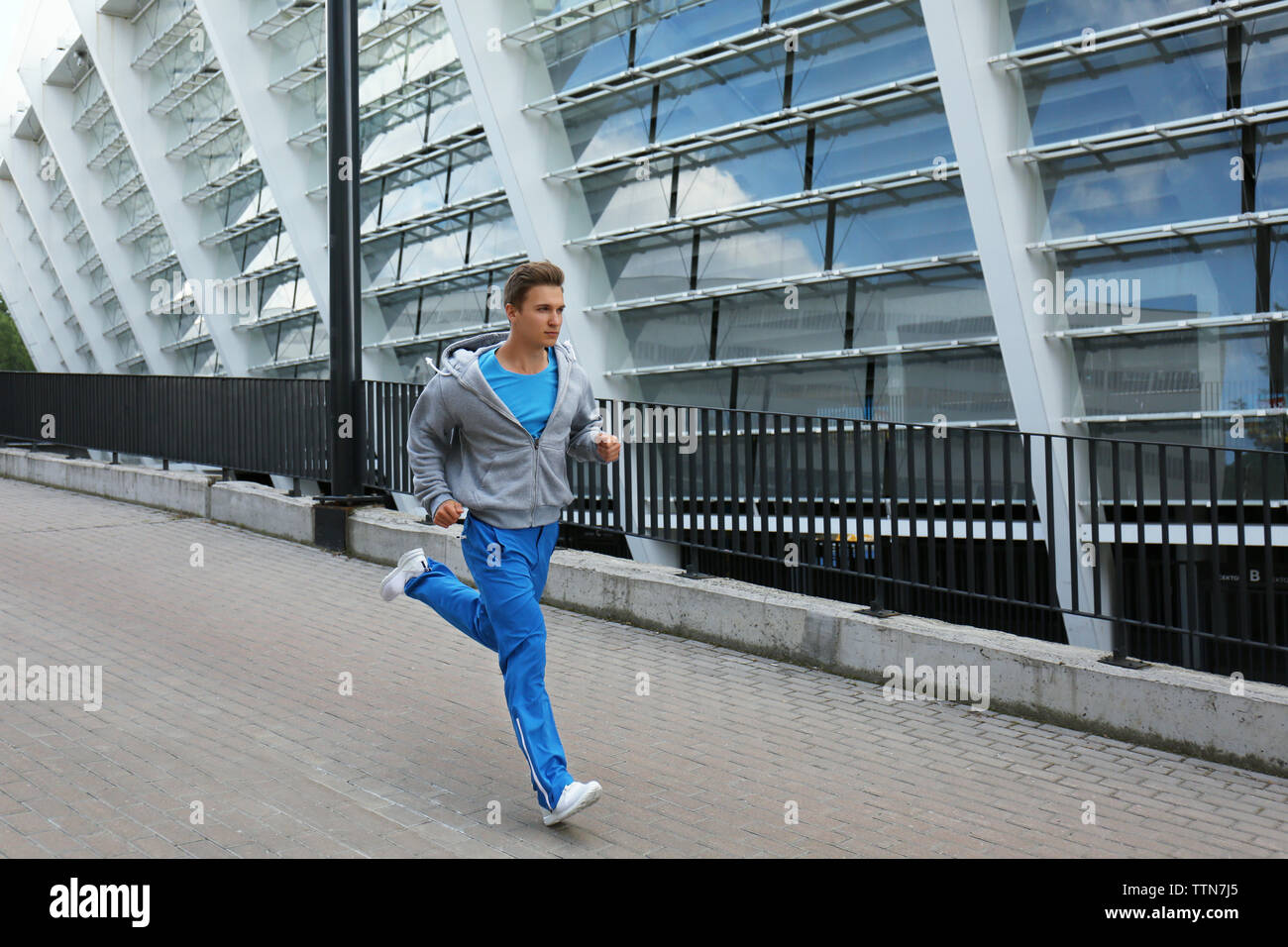 Young man running on the street Stock Photo - Alamy