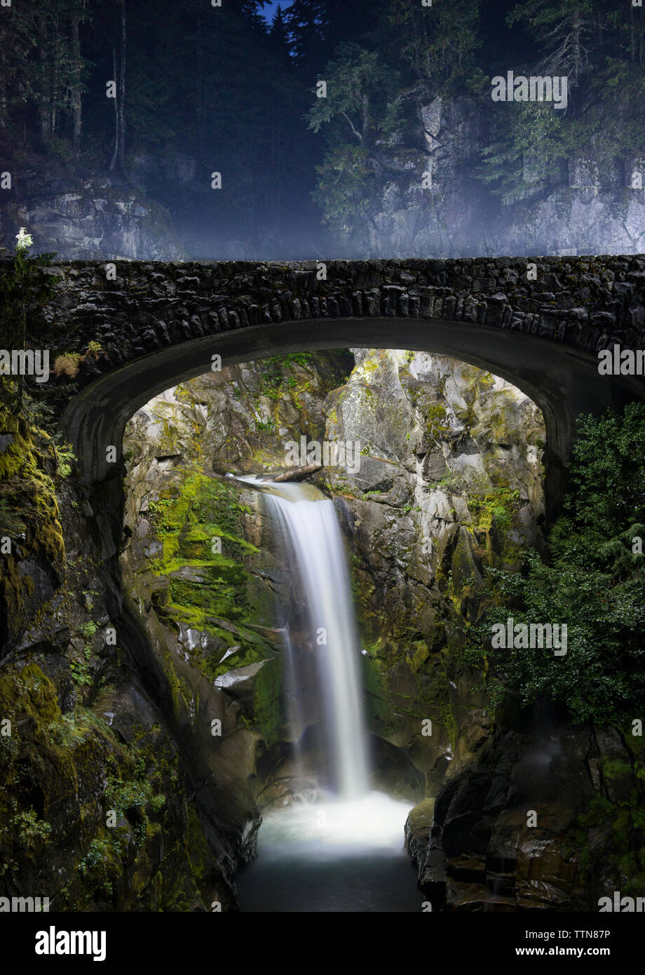 Scenic view of waterfall seen through bridge at Mt Rainier National ...