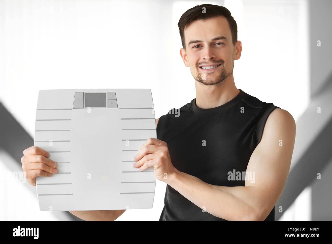 Man holding weight scale Stock Photo - Alamy