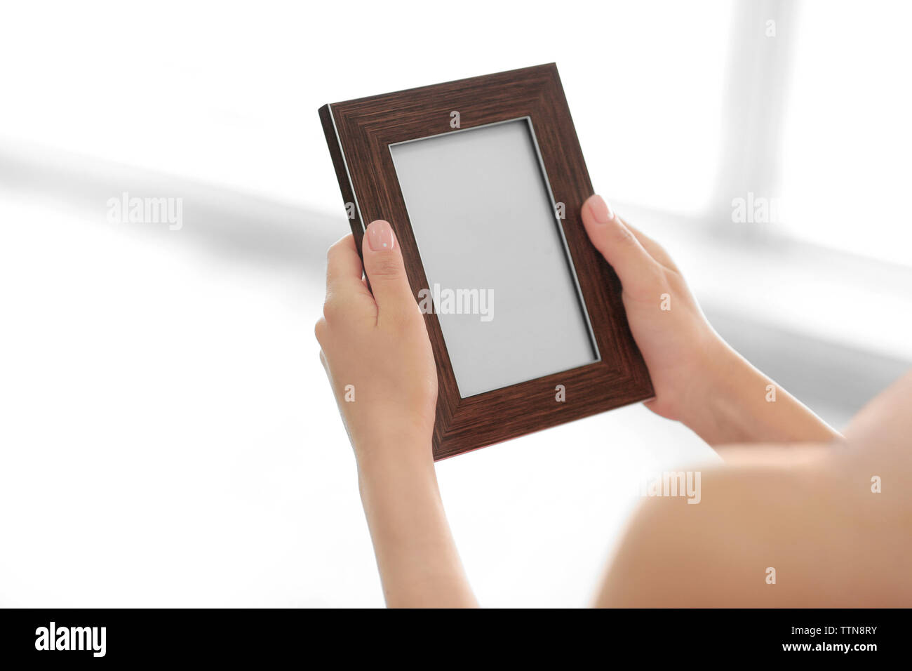 Female hands holding photo frame on light background Stock Photo - Alamy