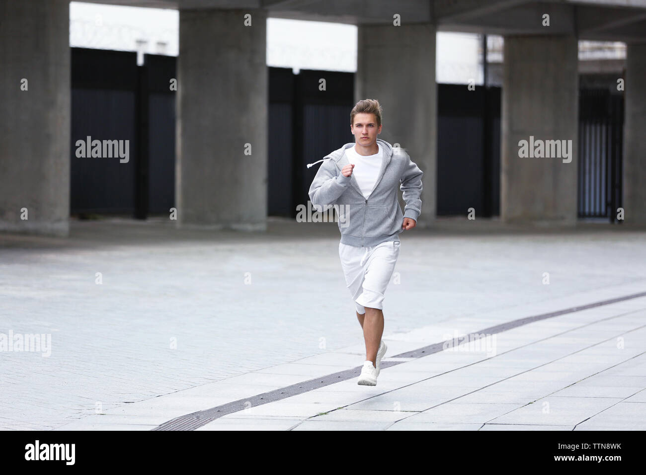 Young man running on the street Stock Photo - Alamy
