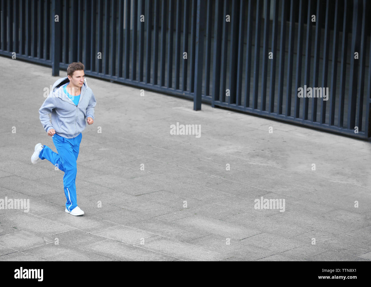 Young man running on the street Stock Photo - Alamy