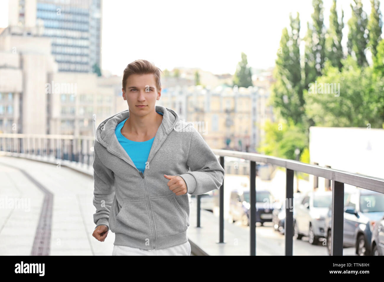 Young man running on the street Stock Photo - Alamy
