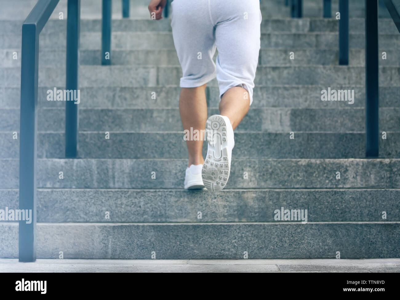 Young man running on stairs Stock Photo - Alamy
