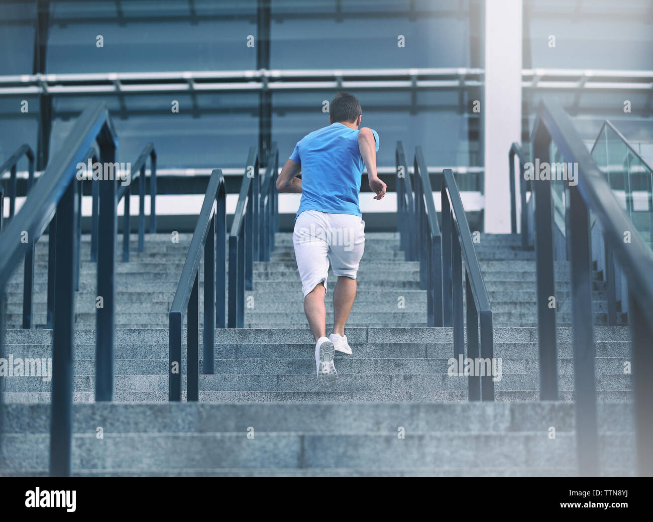 Young man running on stairs Stock Photo - Alamy