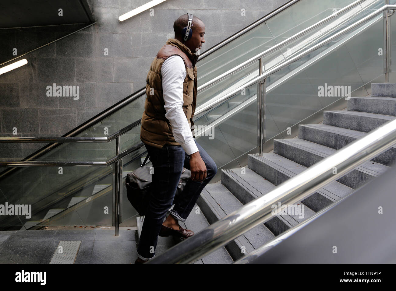 Side view of man climbing steps at subway station Stock Photo - Alamy
