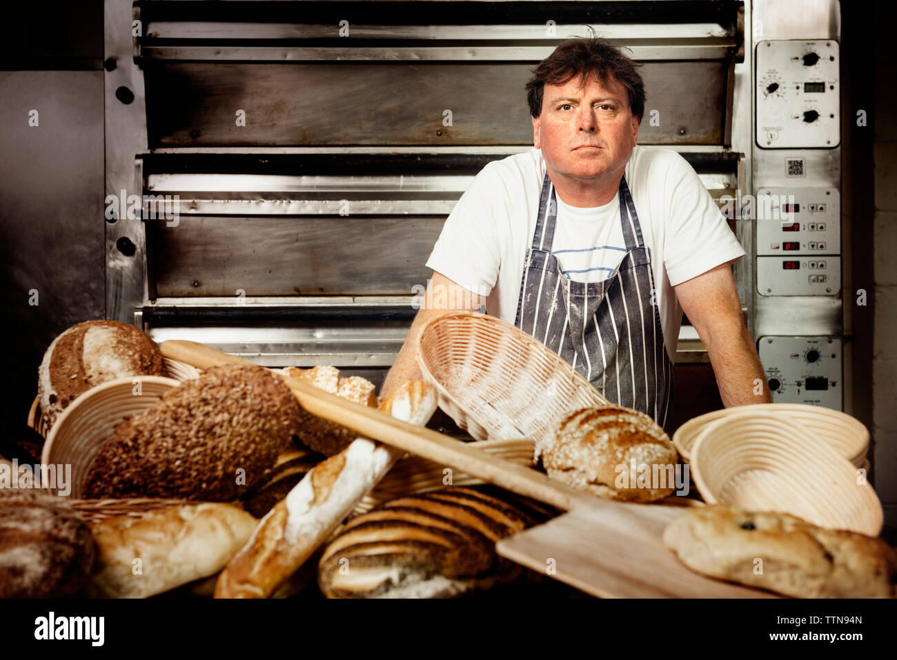 Portrait of confident male baker standing in commercial kitchen Stock ...