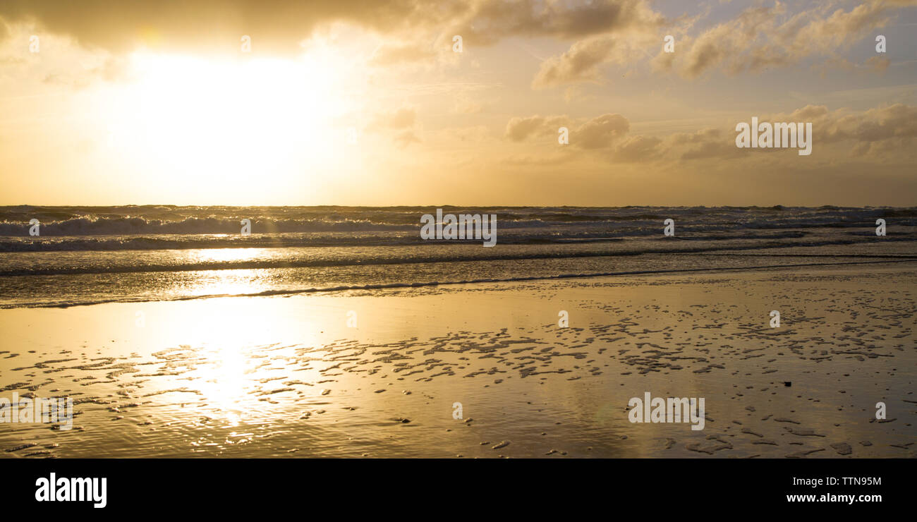 Colorful sunset at the beach with clouds in sky Stock Photo - Alamy