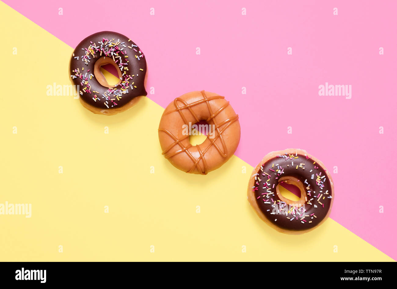 Overhead view of donuts arranged on colored background Stock Photo - Alamy