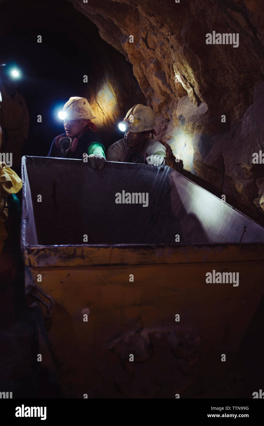 workers holding container in cave at construction site Stock Photo - Alamy