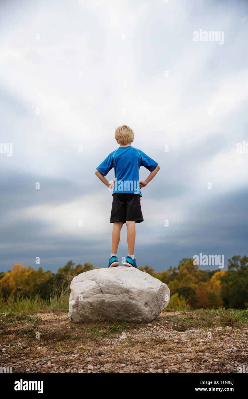 Boy standing on rock under overcast sky Stock Photo - Alamy