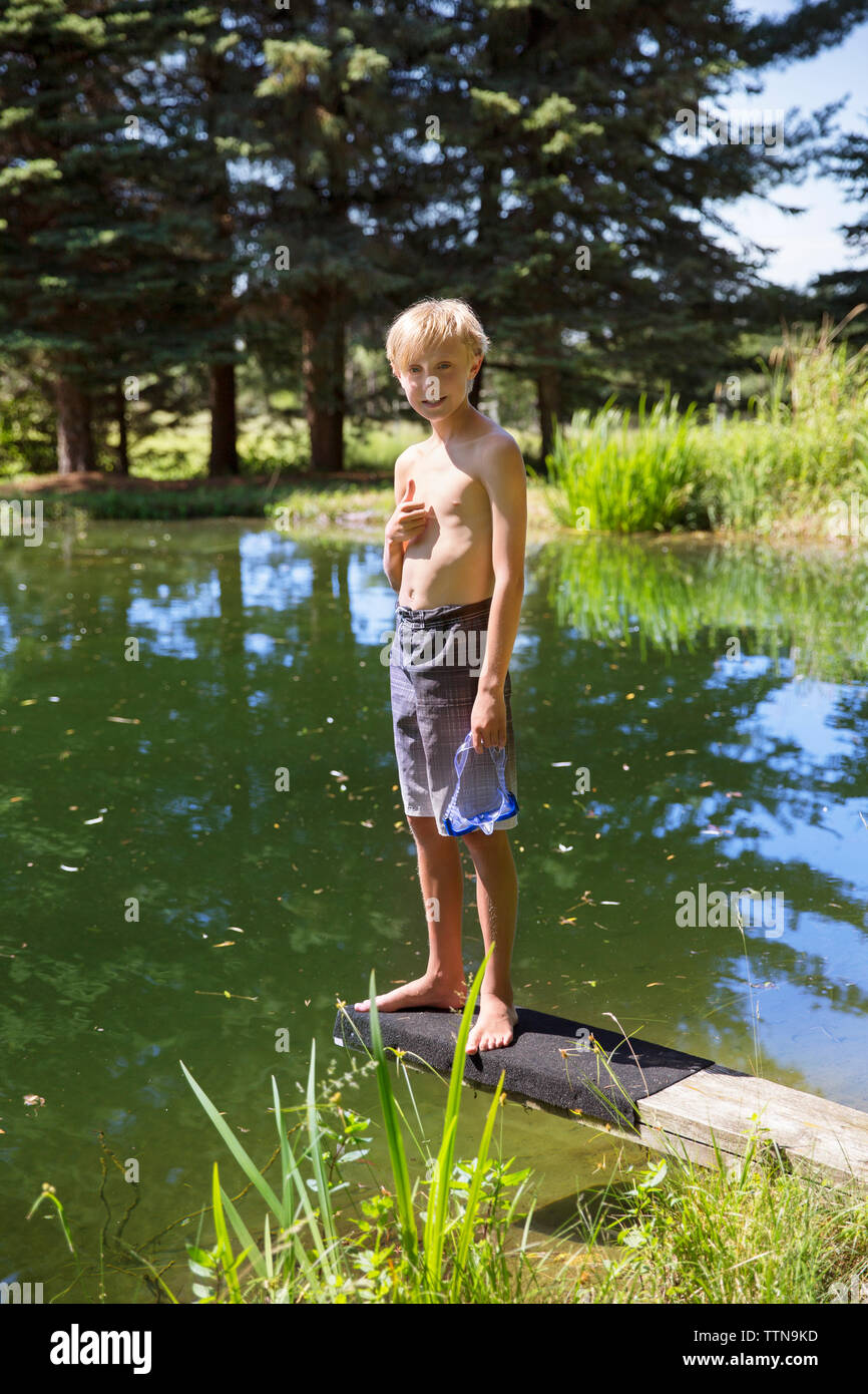 Portrait of boy standing on diving board at lakeshore Stock Photo - Alamy