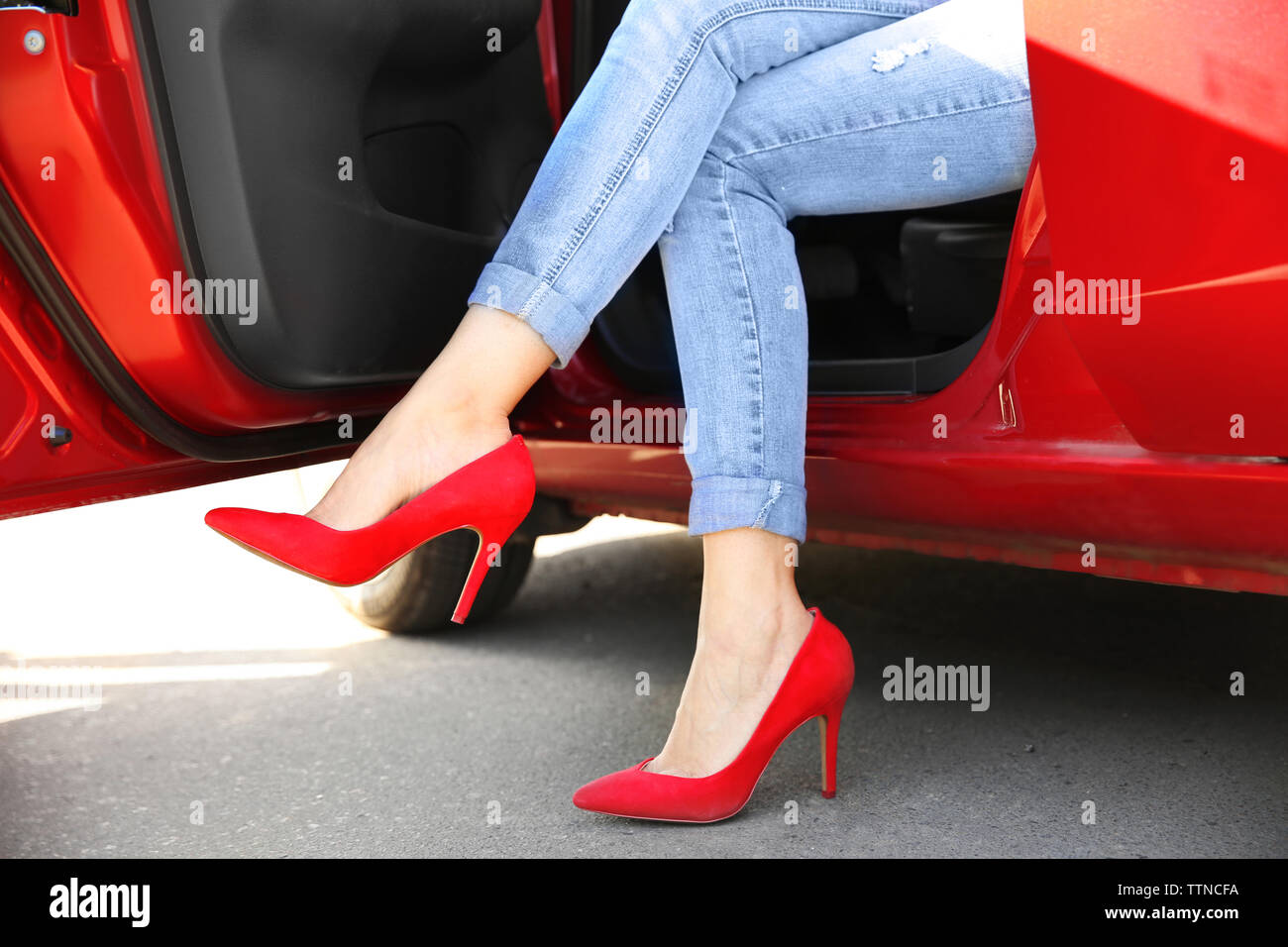 Female legs in red shoes from opened car door Stock Photo - Alamy