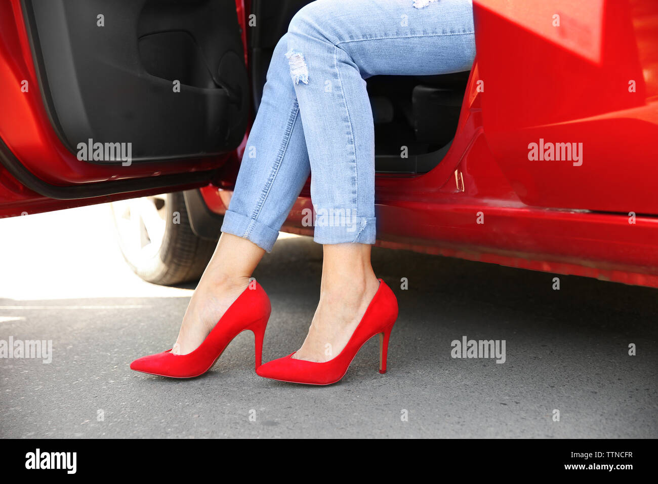 Female legs in red shoes from opened car door Stock Photo - Alamy