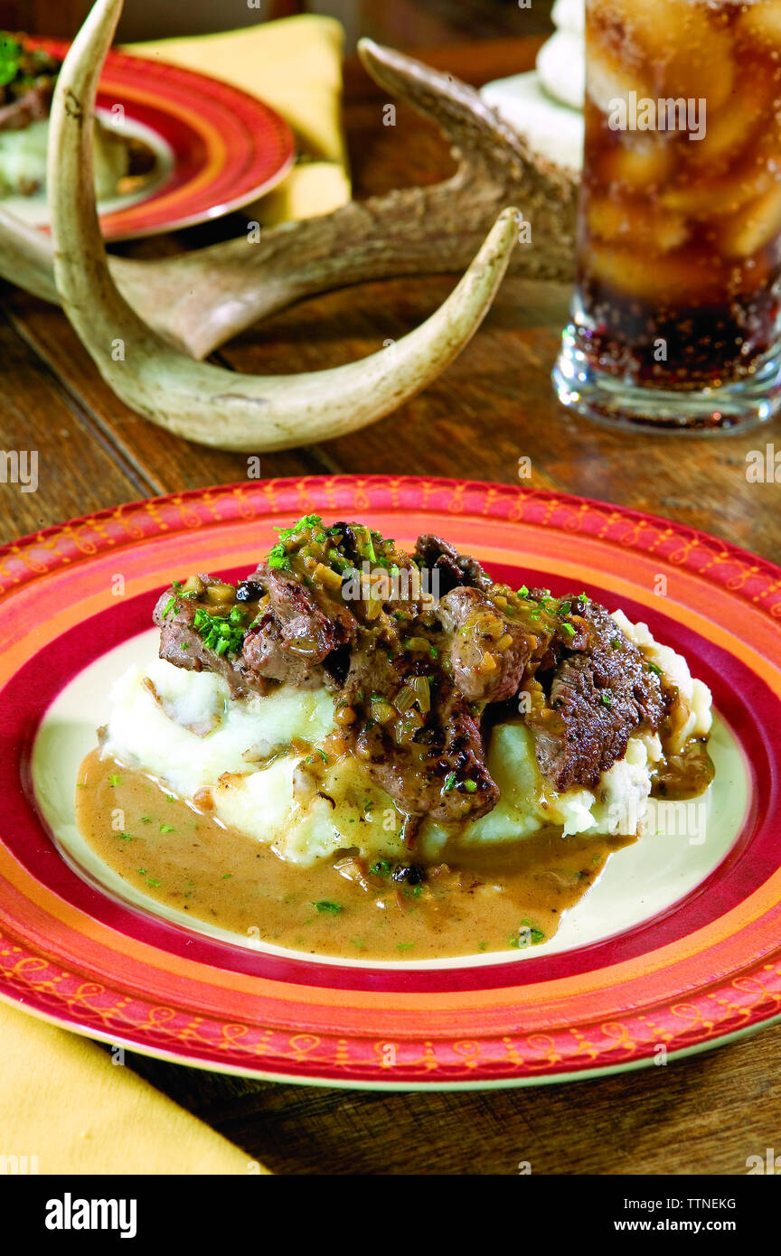 Close-up of cooked meat with mashed food in plate on table at home ...