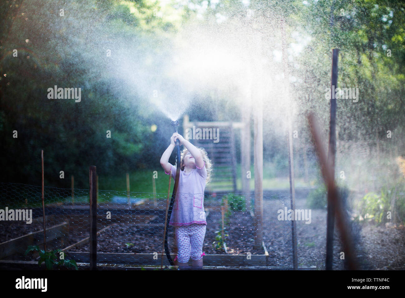 Girl holding water hose hi-res stock photography and images - Alamy