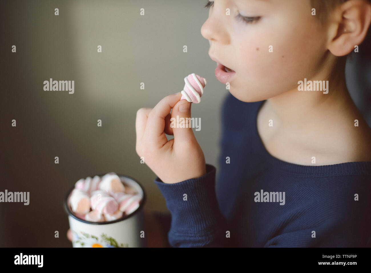 Boy eating marshmallow at home Stock Photo - Alamy