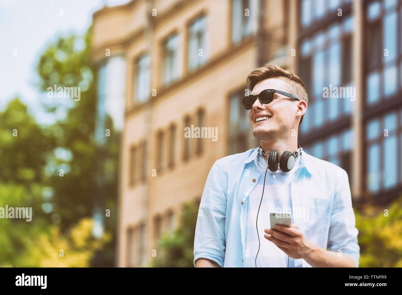 Handsome man listening music on street Stock Photo - Alamy