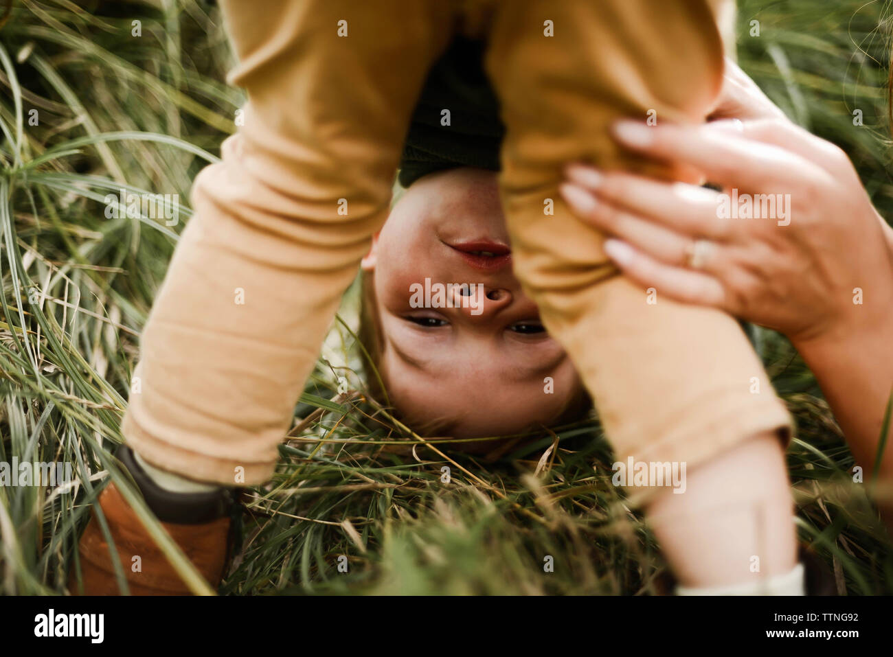 Portrait of a little boy with head down playing outside in the summer ...