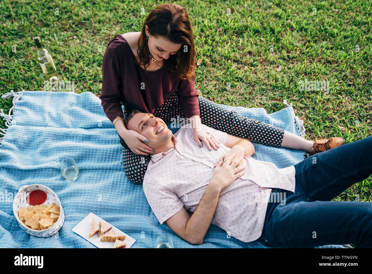 High angle view of husband relaxing on wife's lap at park Stock Photo ...
