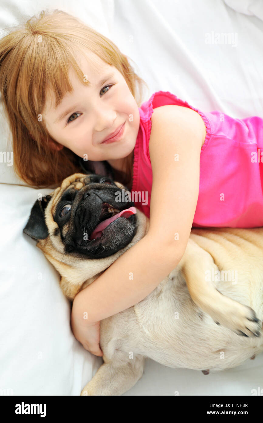 Beautiful girl and cute pug on bed Stock Photo - Alamy