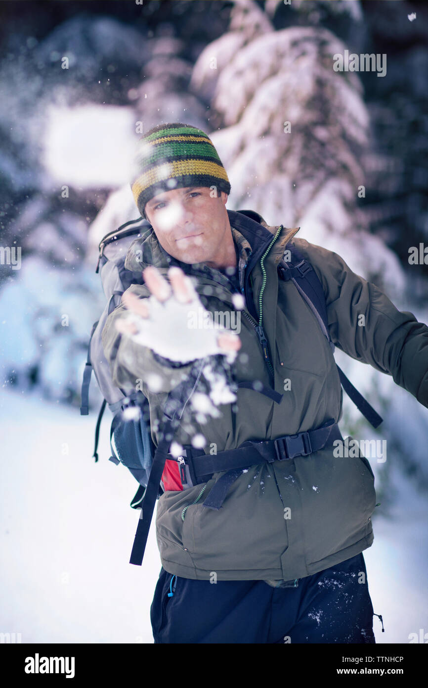 Mid-adult man throwing snowball Stock Photo - Alamy