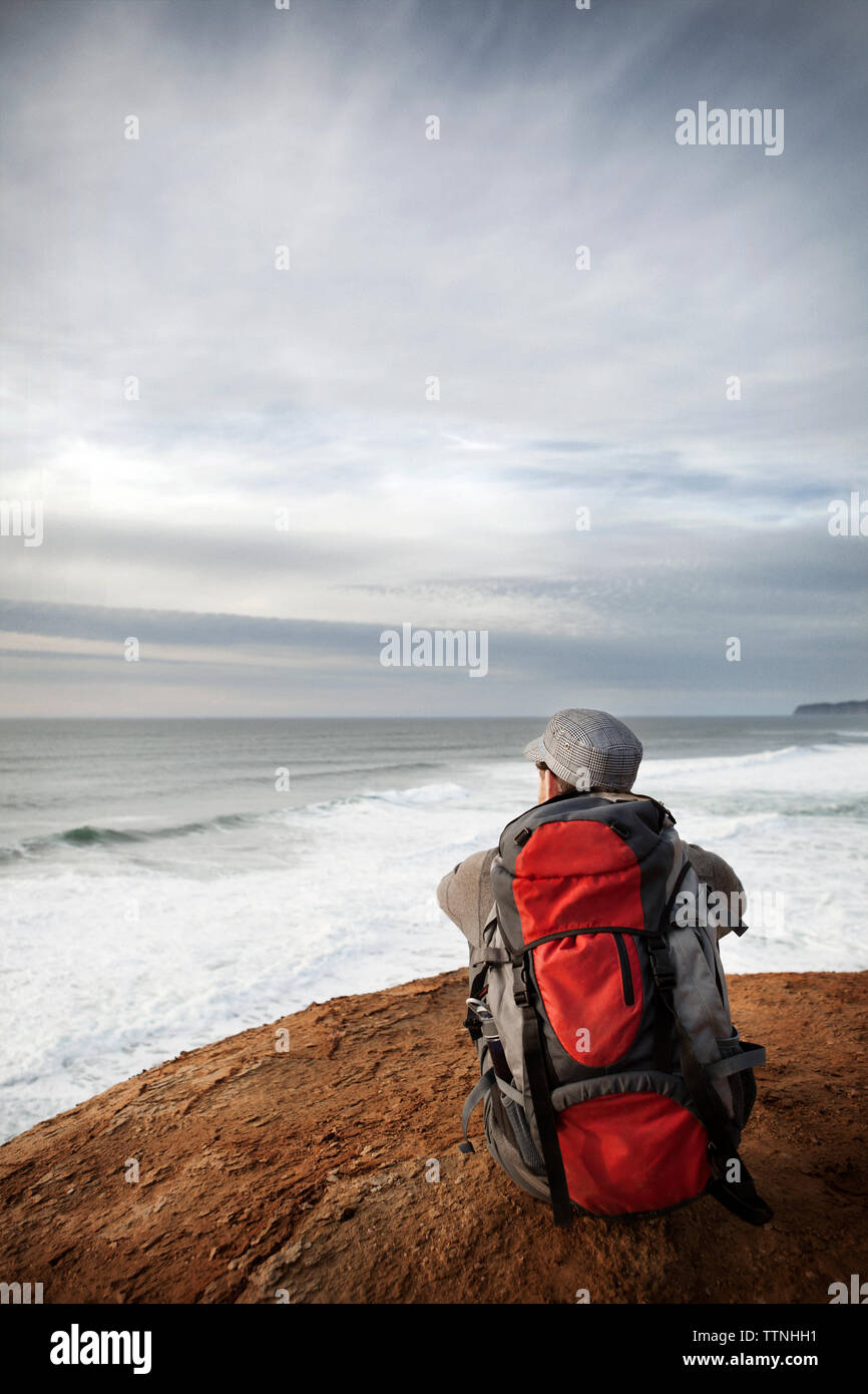 Man sitting on edge of cliff Stock Photo - Alamy